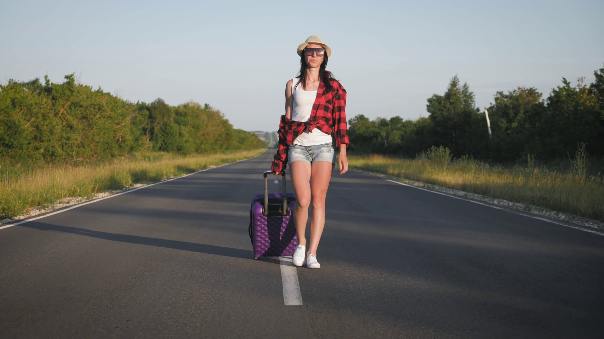 Young woman with a suitcase on road. Funny beautiful girl traveler ...