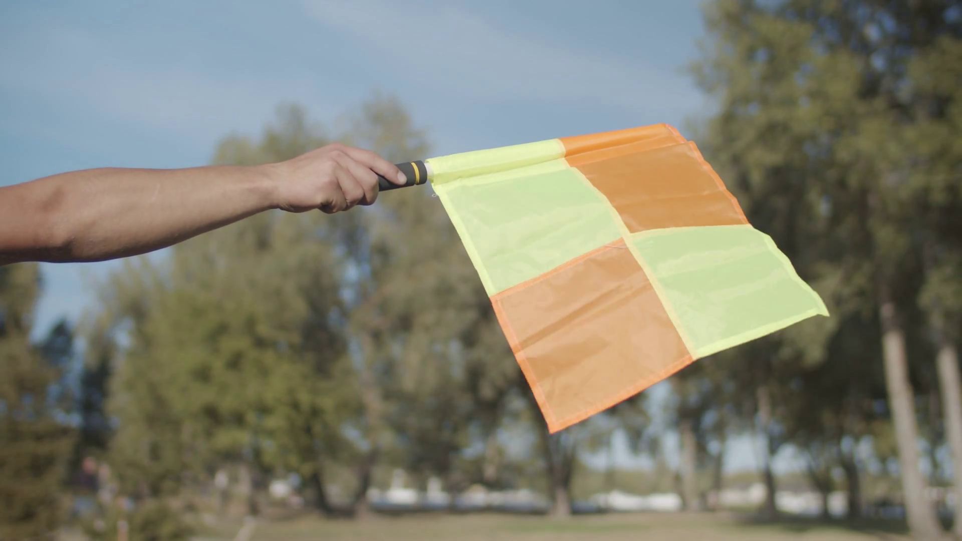Close-up of raised flag for offside of assistant referee during soccer ...