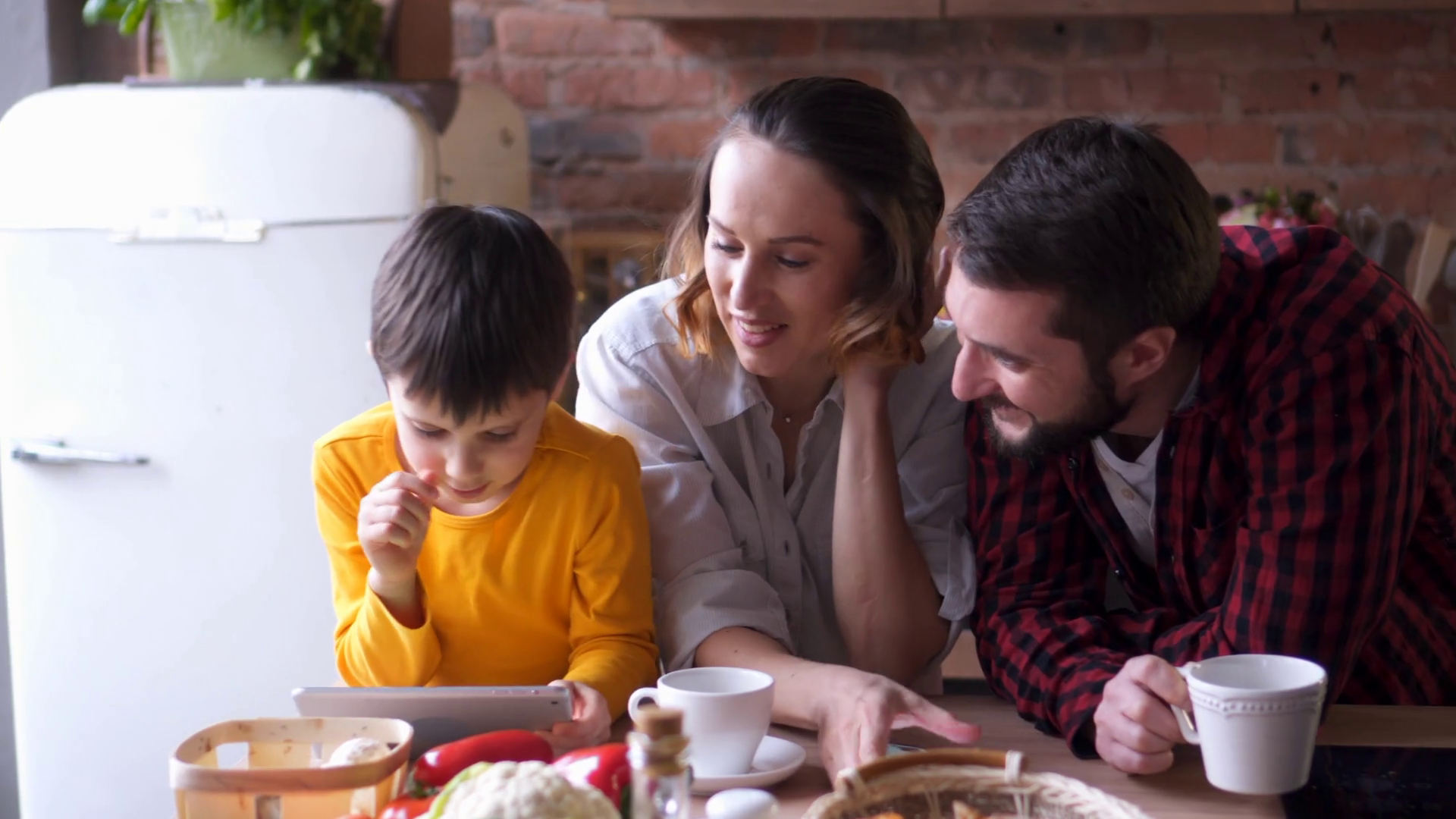 Family spending morning time at the kitchen with coffee and digital ...