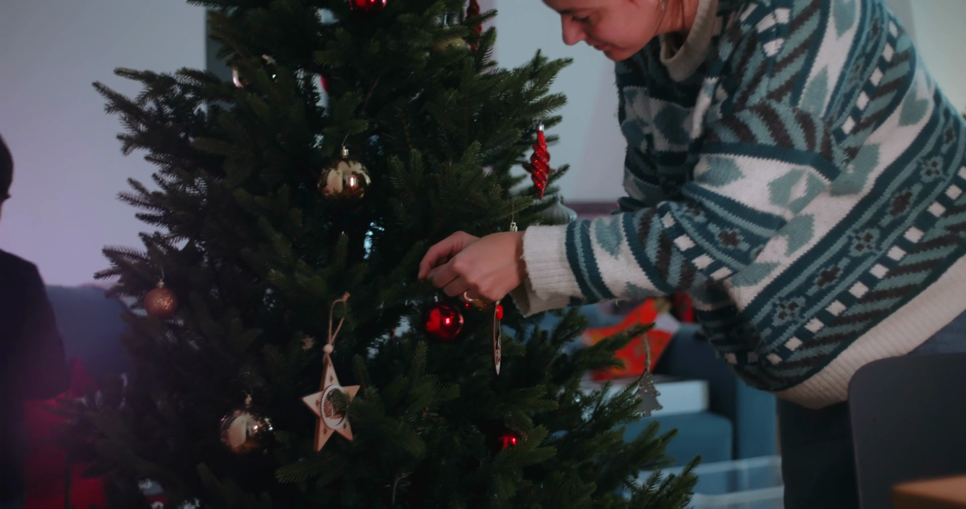 Mother Adding Ornaments To Christmas Tree In Stock Footage SBV ...