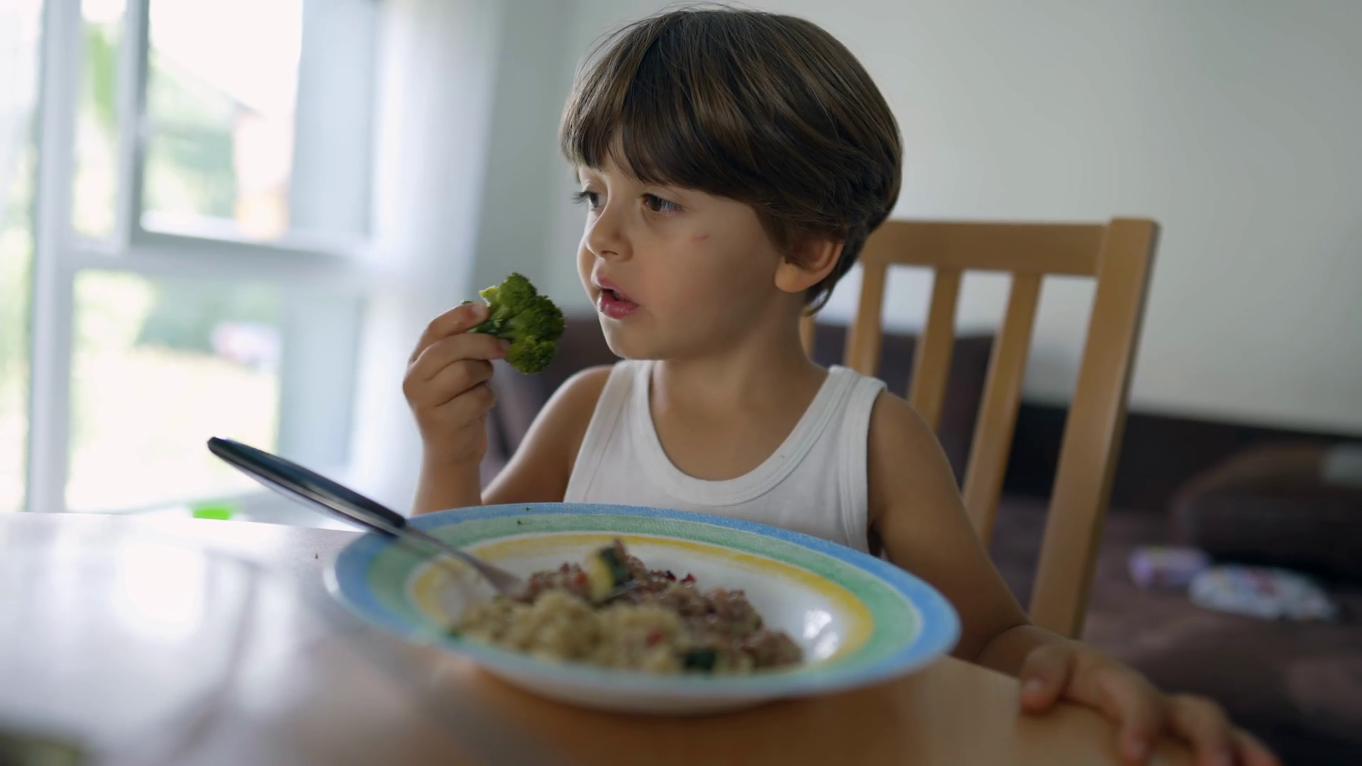 Child Sitting At Lunch Table Eating Broccoli Stock Footage SBV ...