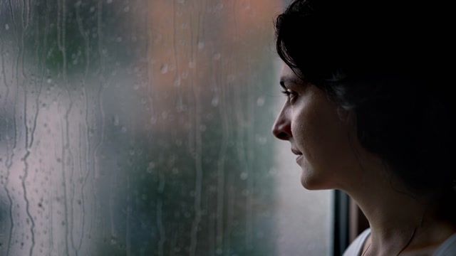 Sad Woman Looking The Rain Falling Through A Window At Home Or Hotel ...