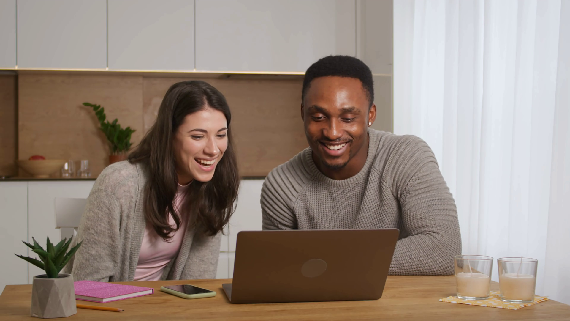 A couple having an online conference video call with their friends at ...