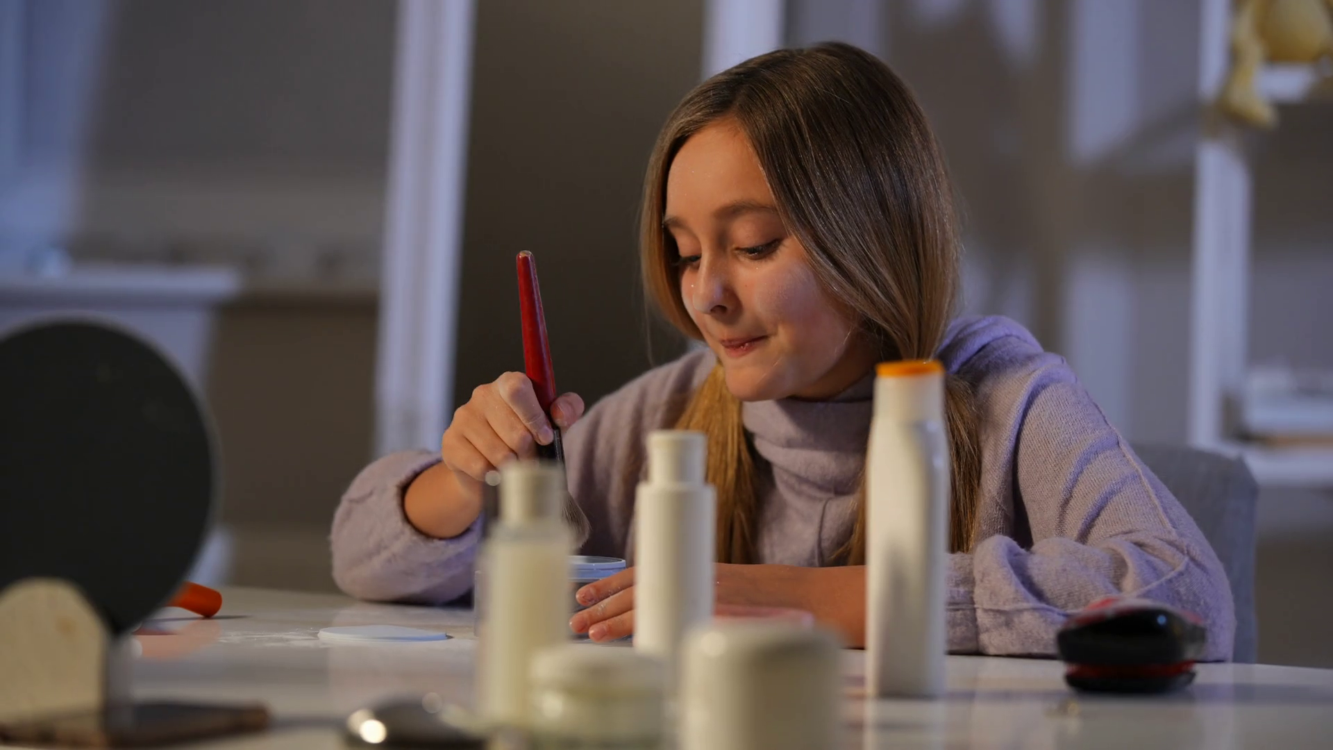 Joyful carefree teenage girl applying face powder on chin nose and ...