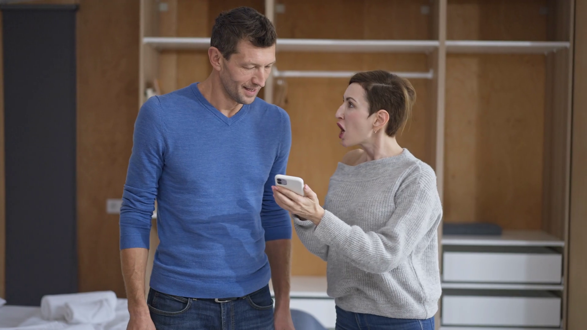 Furious jealous beautiful wife showing smartphone yelling at sad ...