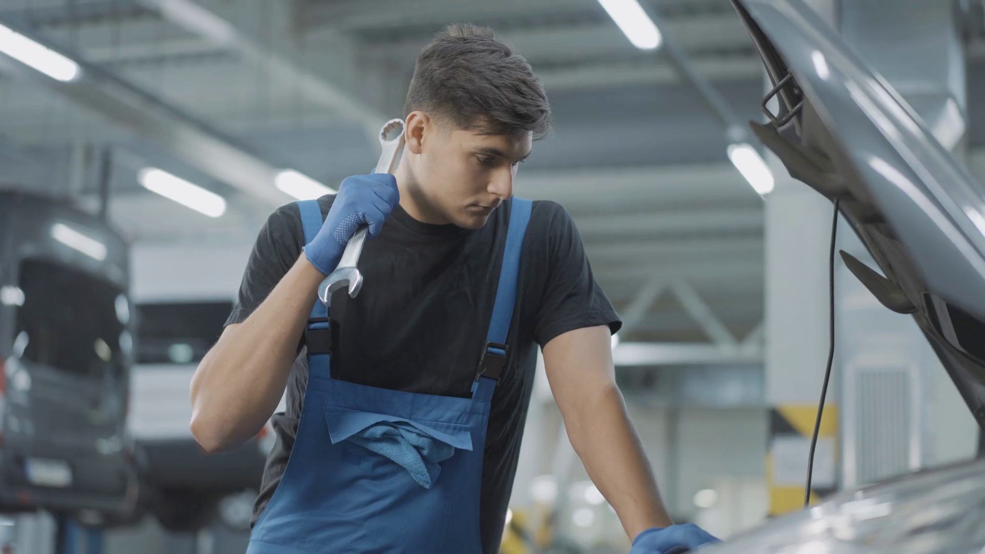Portrait of serious young repairman scratching head with adjustable ...