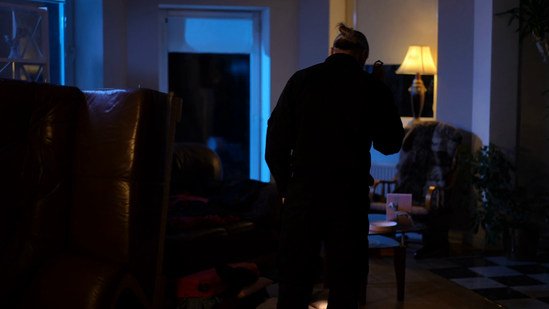 Back view policeman with flashlight walking inside robbed house ...