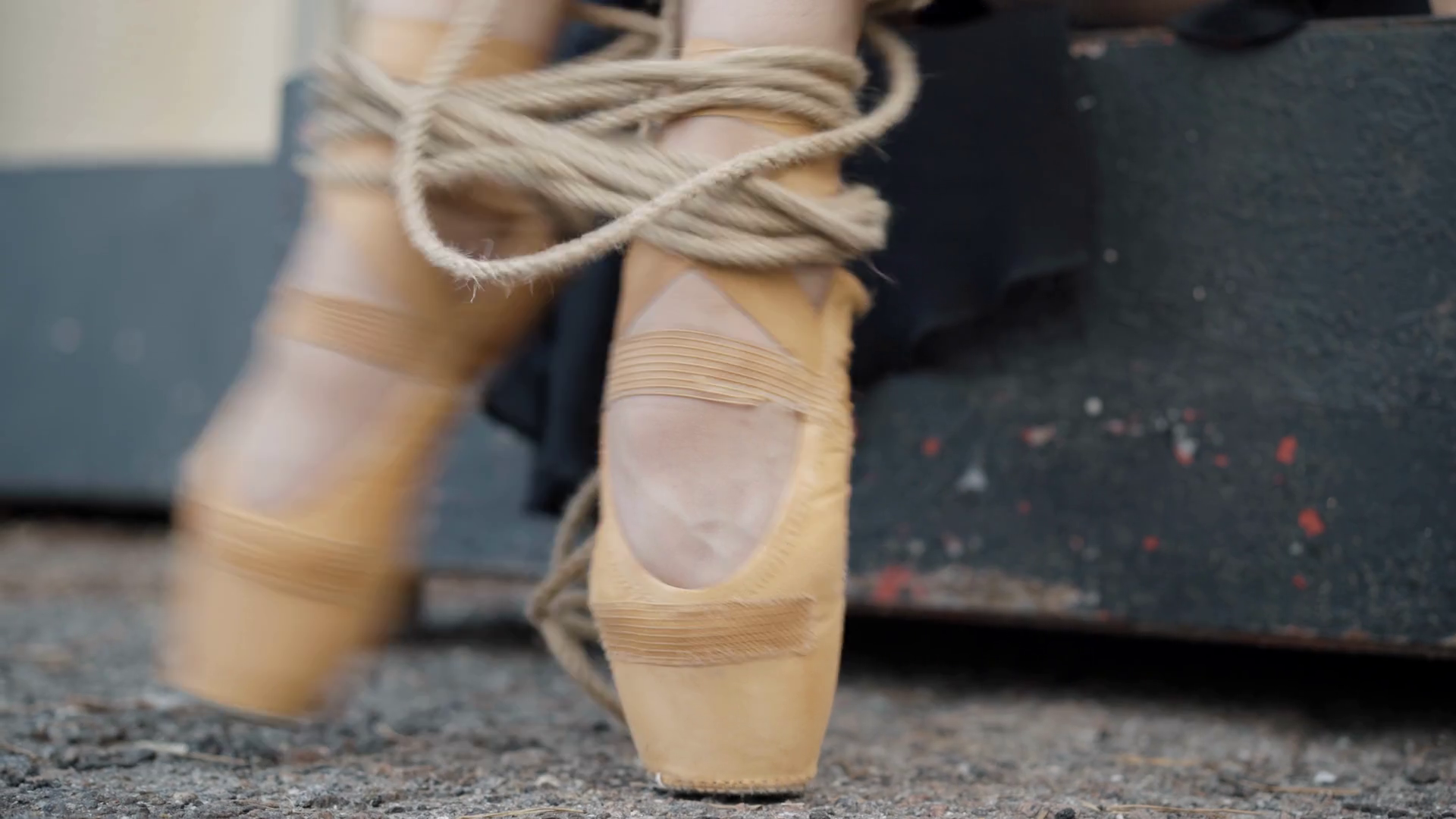 Close-up feet of slim woman in yellow pointes trying to break free from ...