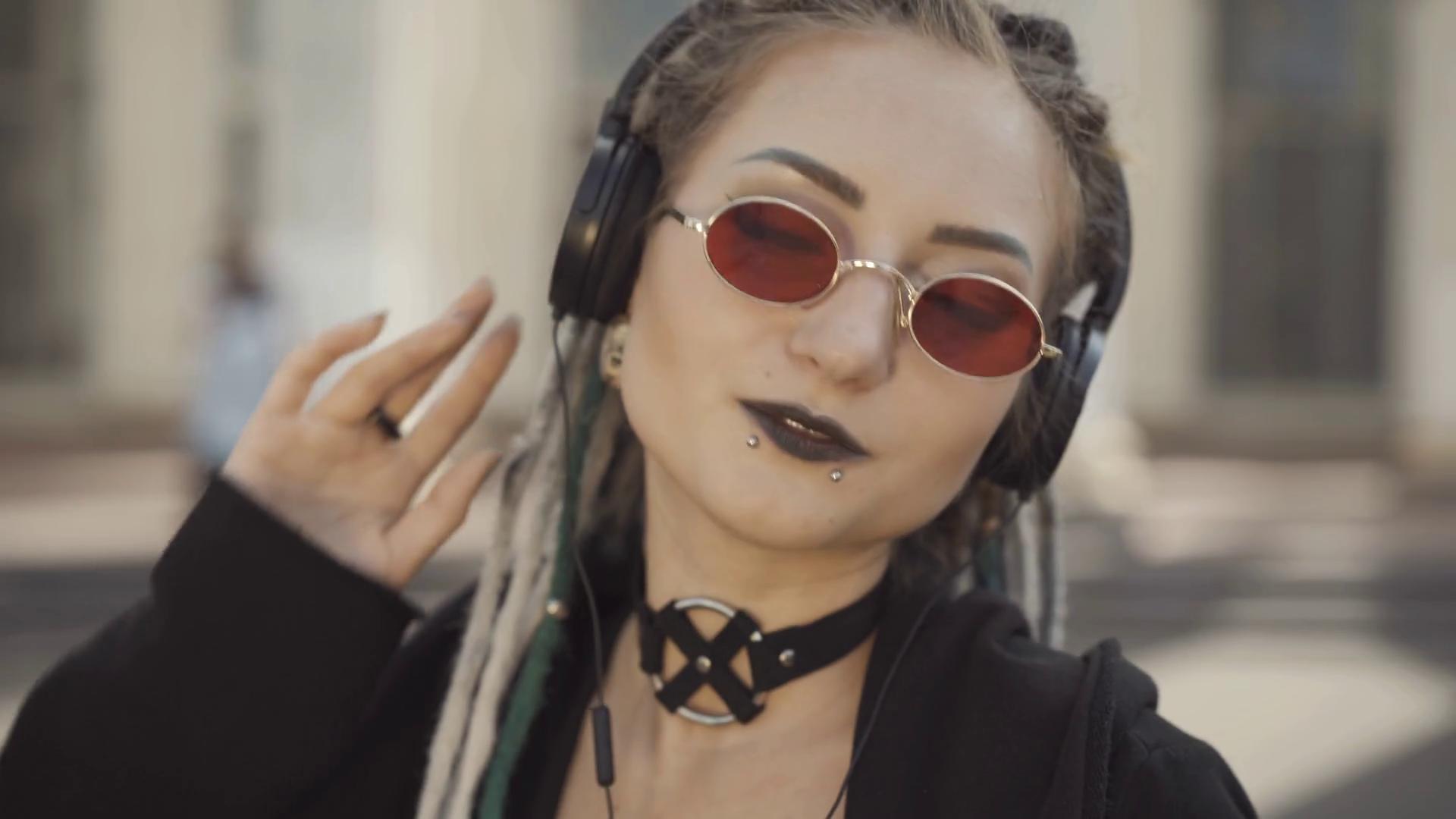 Close-up headshot of confident young goth woman dancing to music in ...