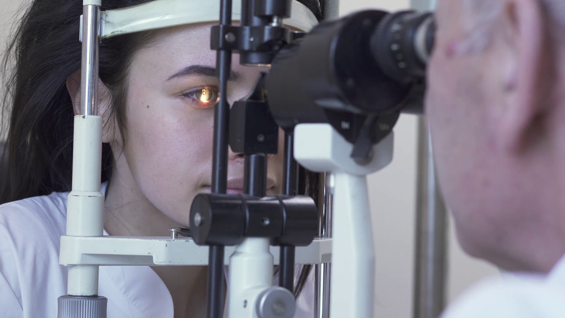 Pretty Caucasian Woman Do Eye Test At Clinic Sitting In Front Of Doctor pretty-caucasian-woman-do-eye-test-at-clinic-sitting-in-front-of-doctor