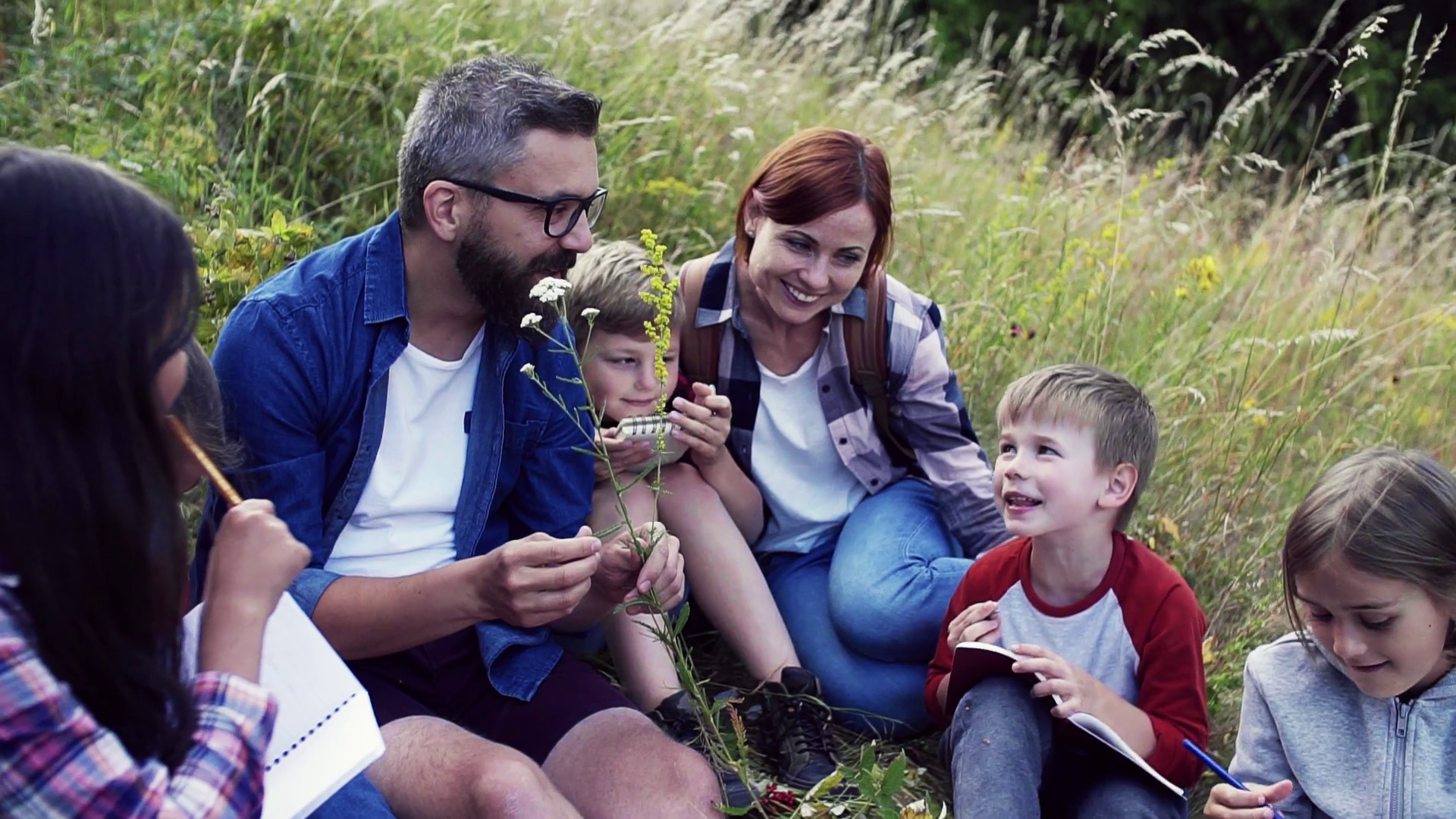 A group of small school children with teacher on field trip in nature ...
