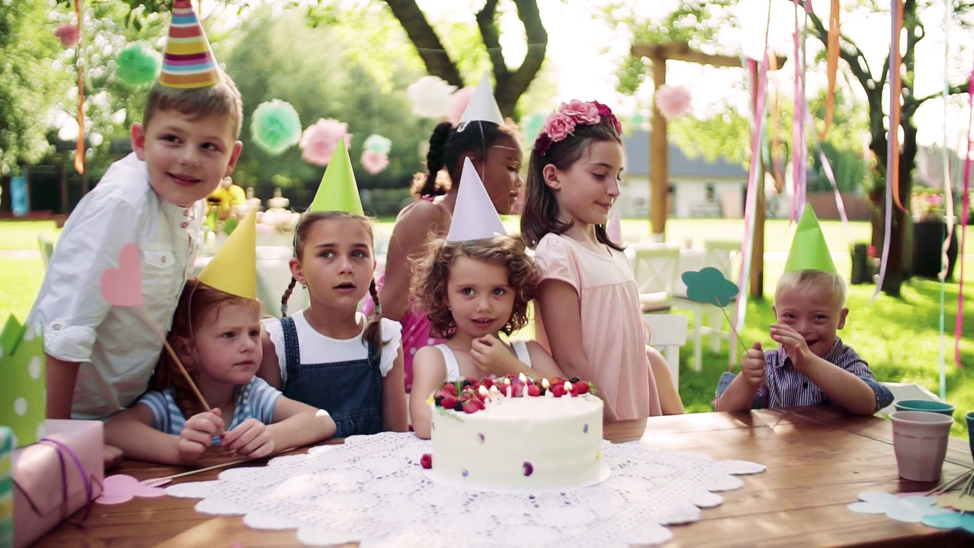 Down syndrome child with friends on birthday party outdoors in garden ...