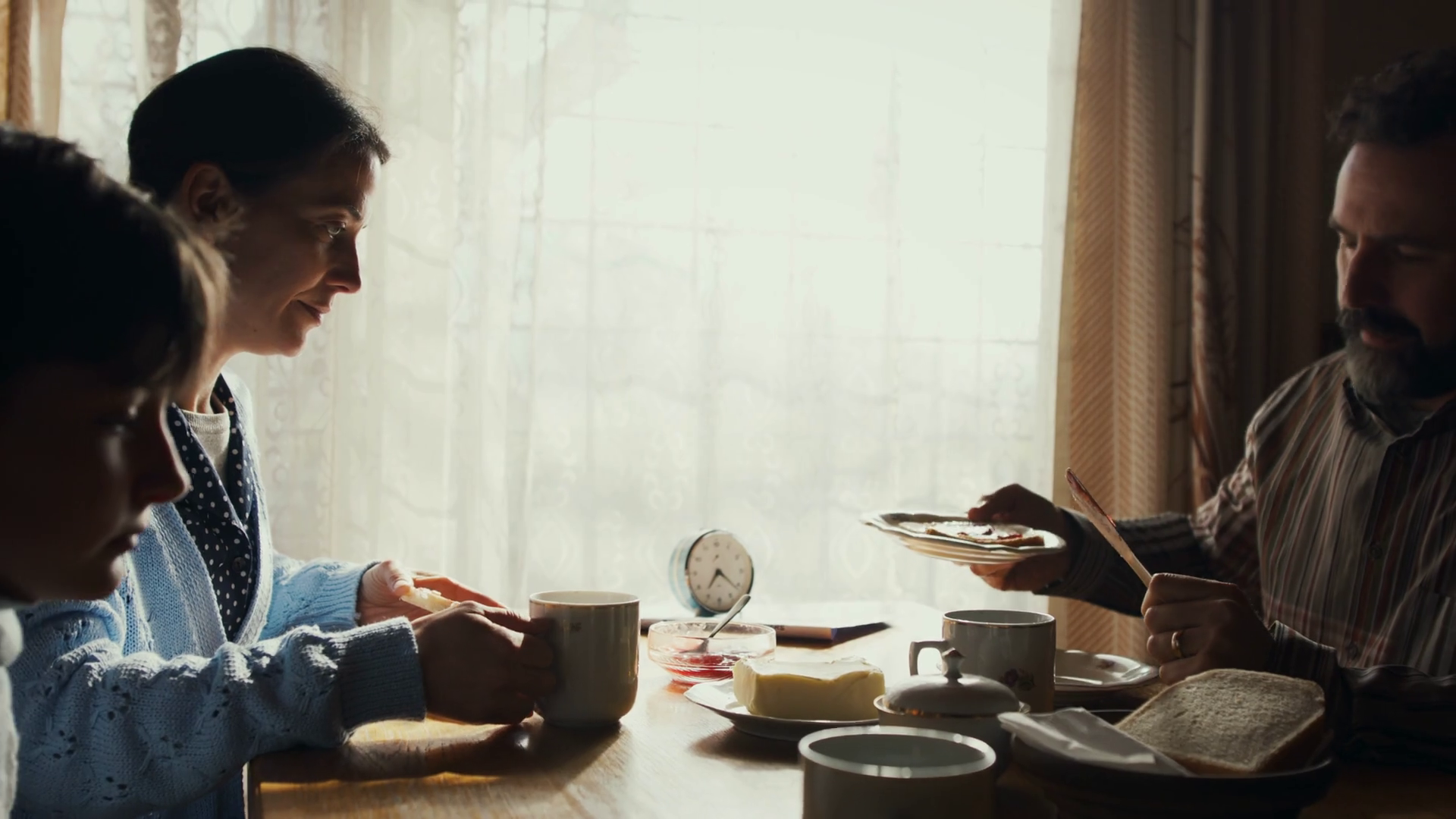 Side view of unhappy poor family having a breakfast indoors at home ...