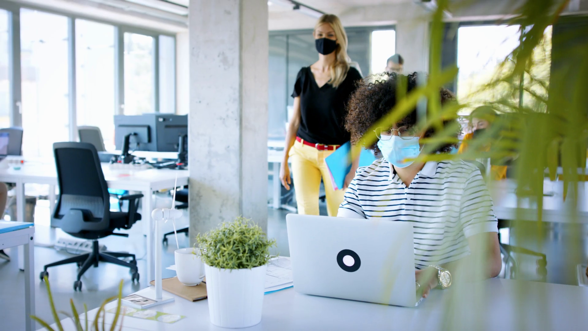 Young people with face masks back at work in office after coronavirus ...