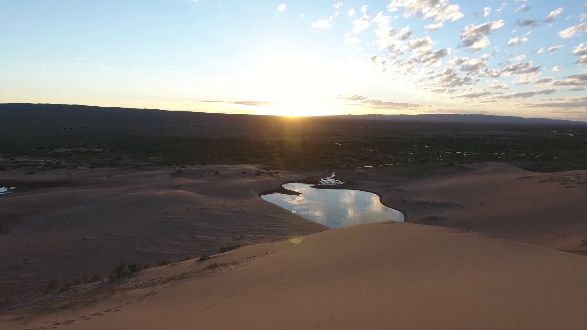 Aerial drone shot in Gobi desert following sand dune toward an ...