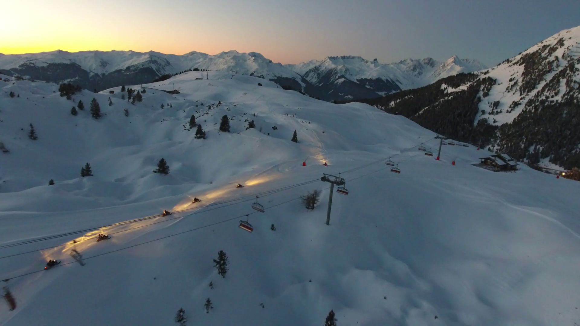 Snowmobiles in the french Alps by drone. Sunset time snowy mountains ...
