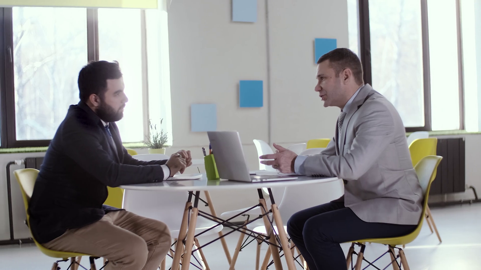 Two businessmen sitting at a round table, are negotiating the upcoming ...