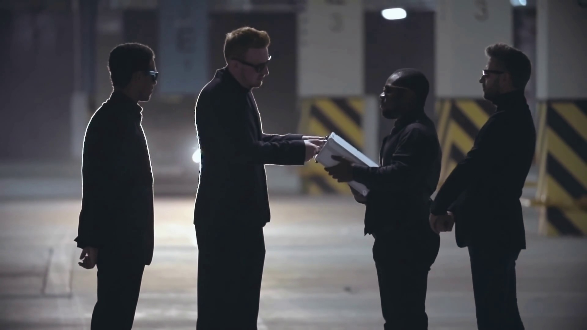 Two gangsters walking towards other criminals, one of them opening ...