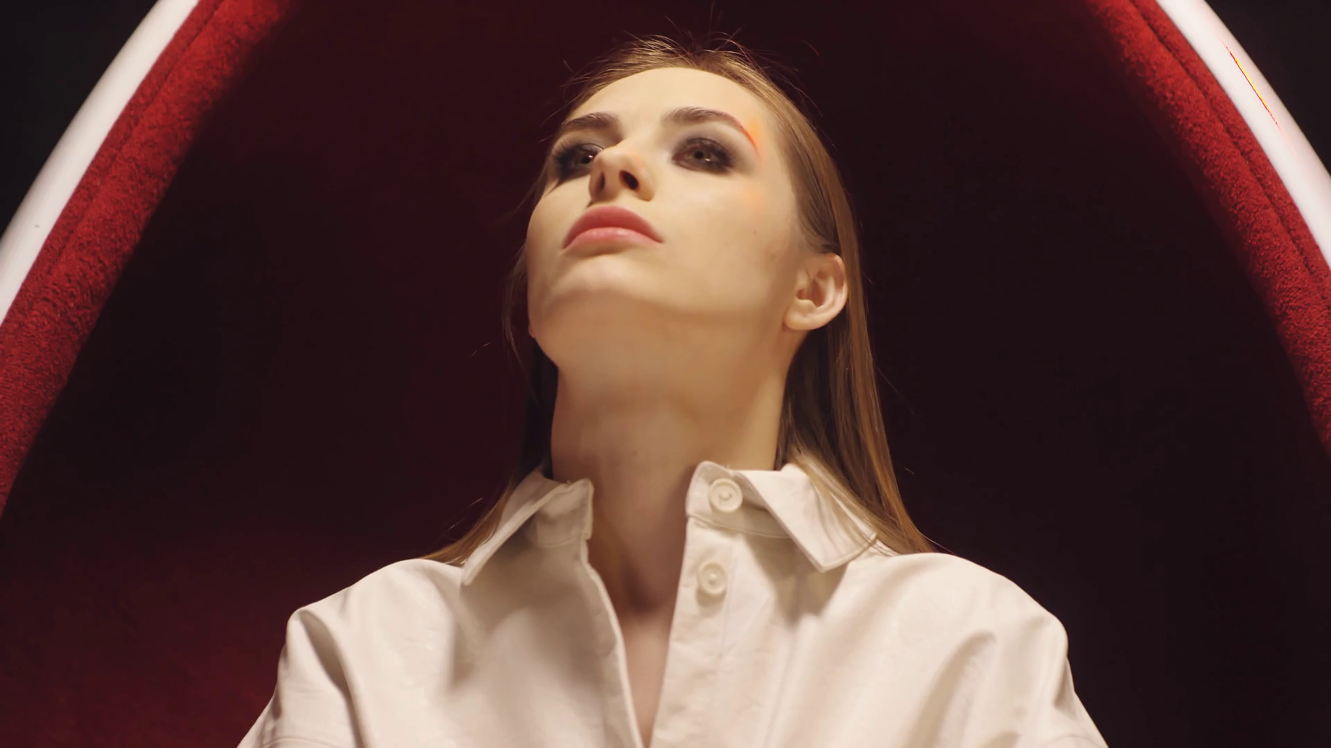 Chest up shot of young gorgeous woman with smoky eyes makeup sitting in ...