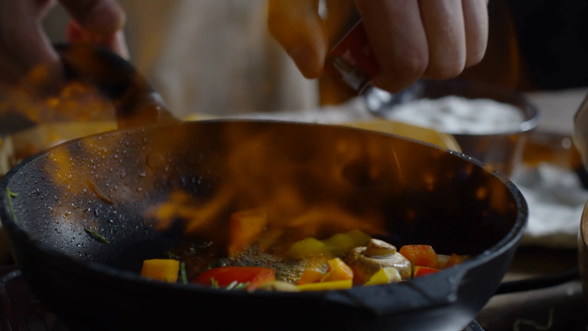 Close up of male hand cooking vegetables, doing flambé and tossing ...