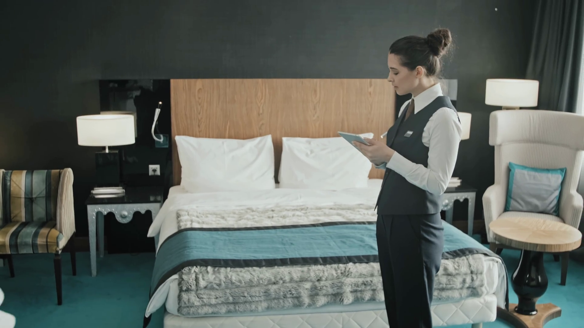 Medium shot of female hotel manager with digital tablet checking room ...