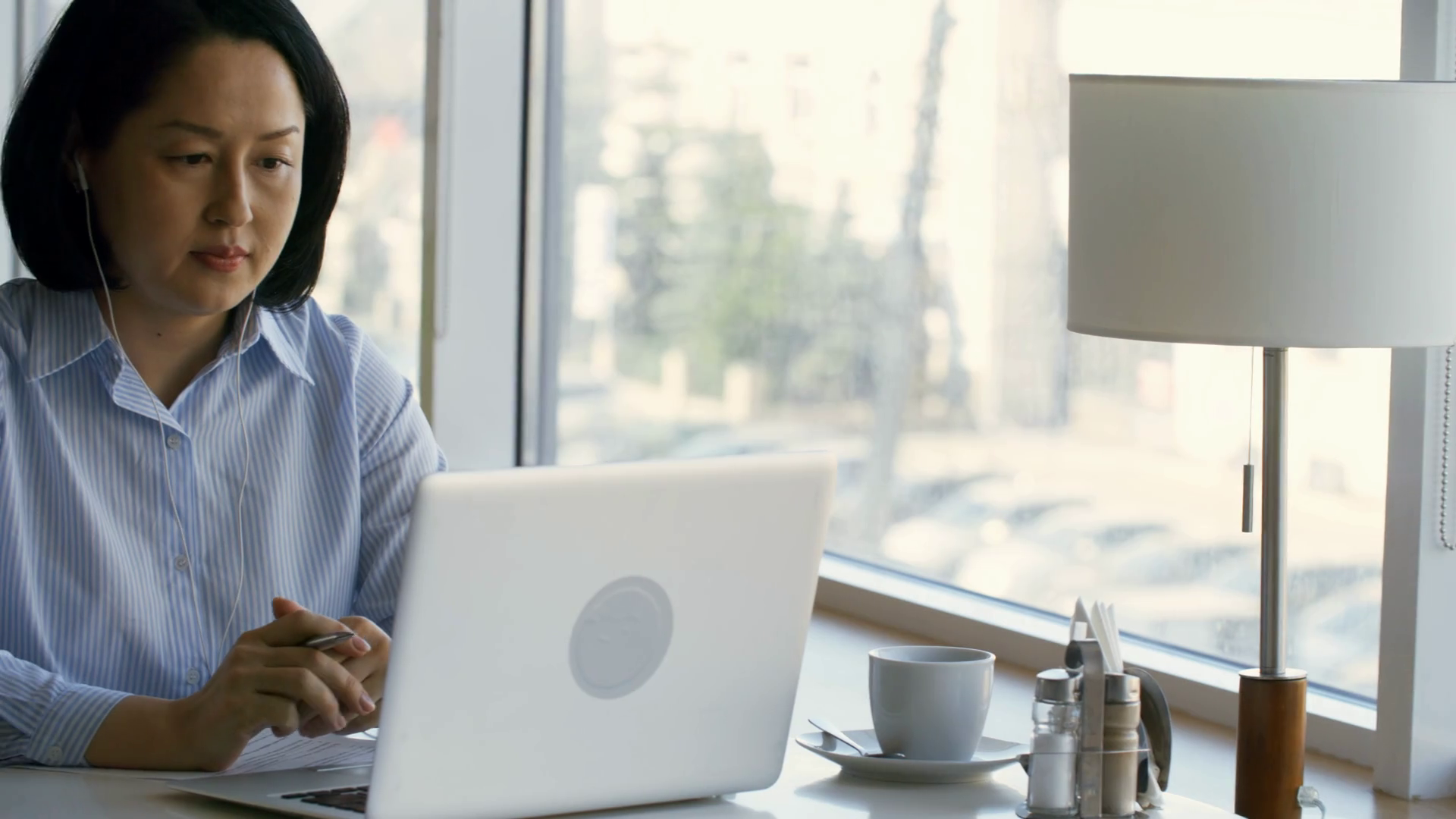 Medium tracking shot of polite Asian woman using laptop computer when ...