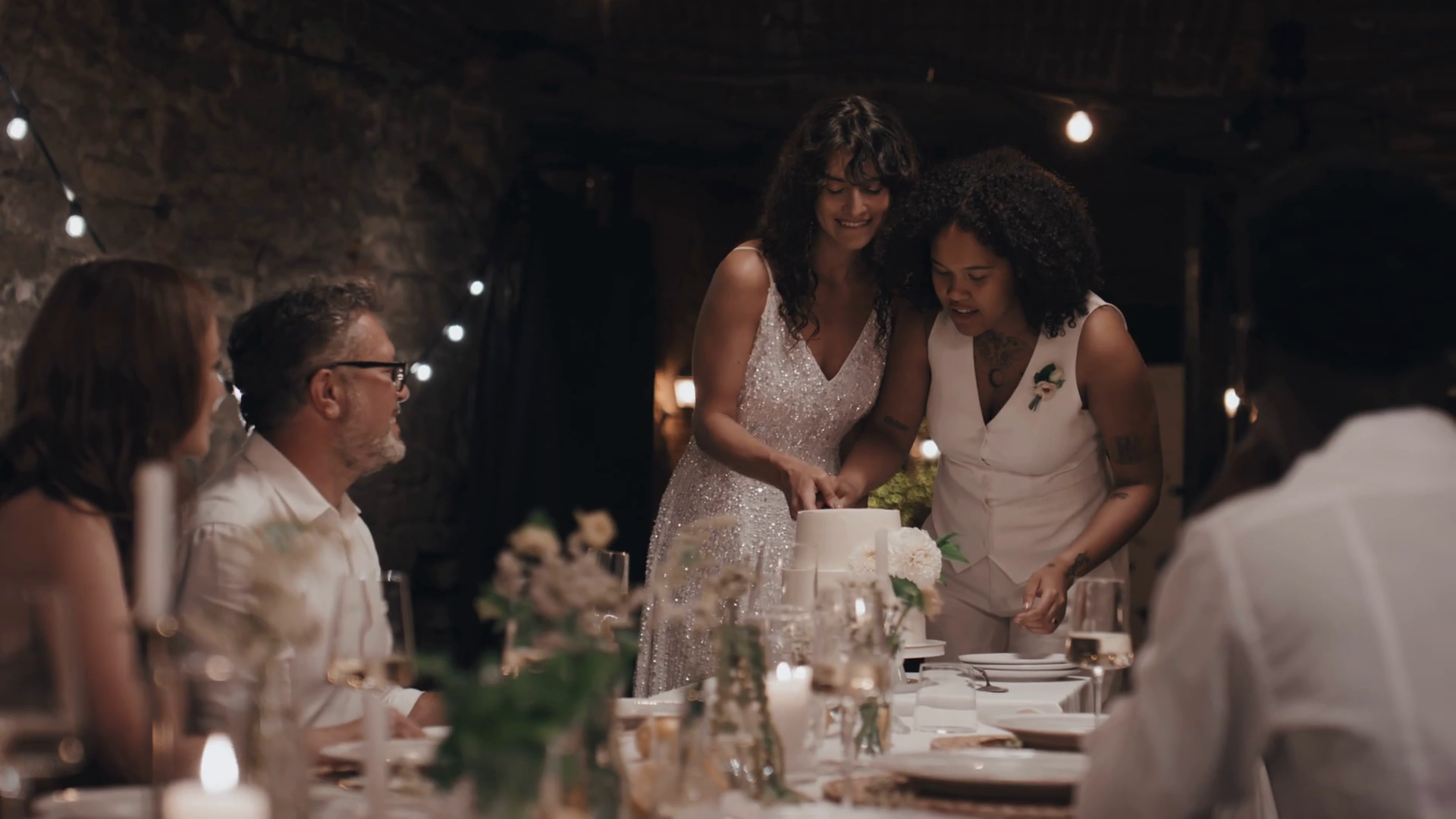 Young lesbian couple cutting wedding cake together during festive ...