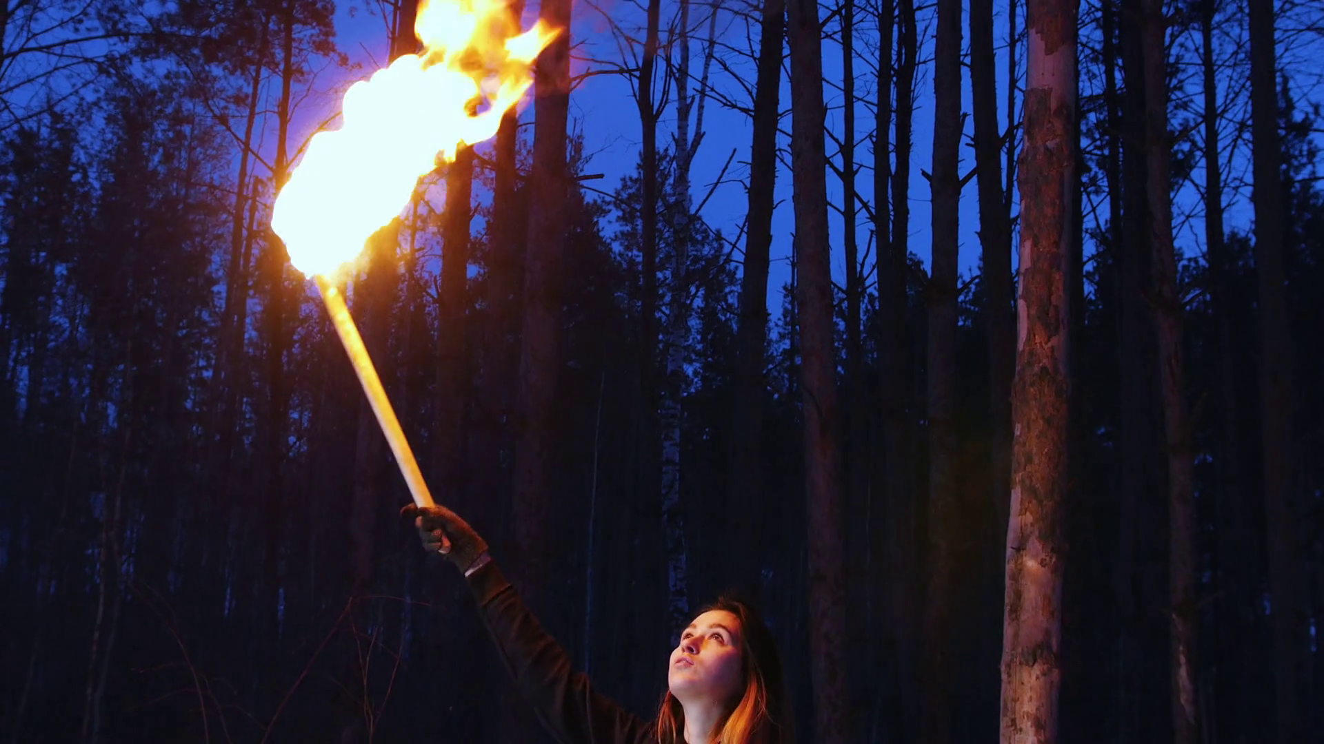 A woman overhead waving with torch standing in winter forest Stock ...