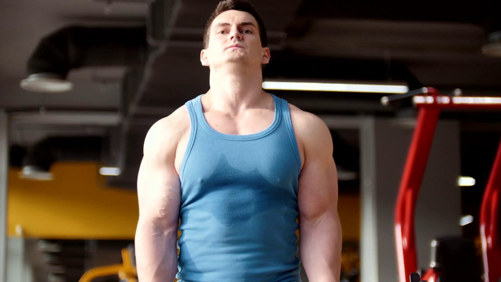 Bodybuilding in the gym - muscular man training his biceps near mirror ...