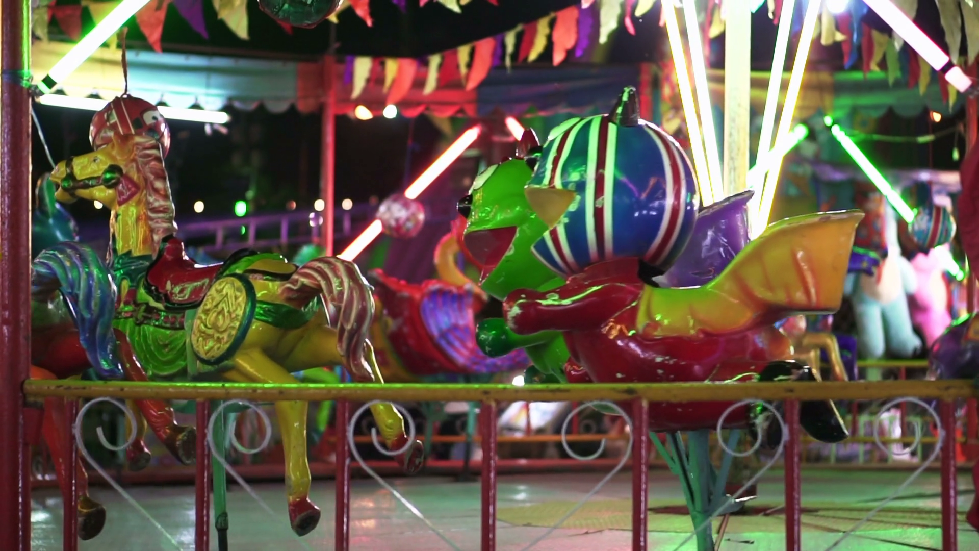 Scary animal carousel in colorful painting. Cheap Asian carnival fair ...