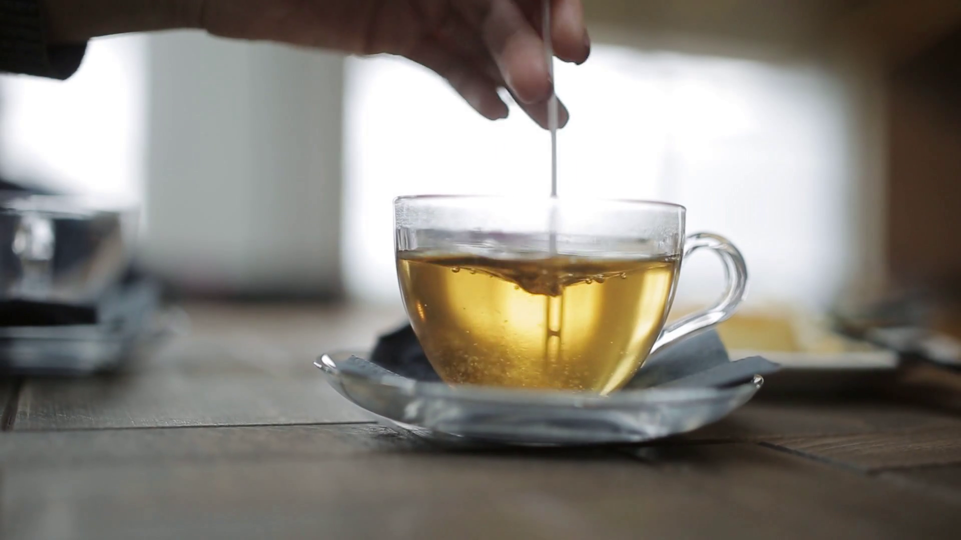 Woman's hand stir the sugar in a Cup of tea in a cafe at the airport ...