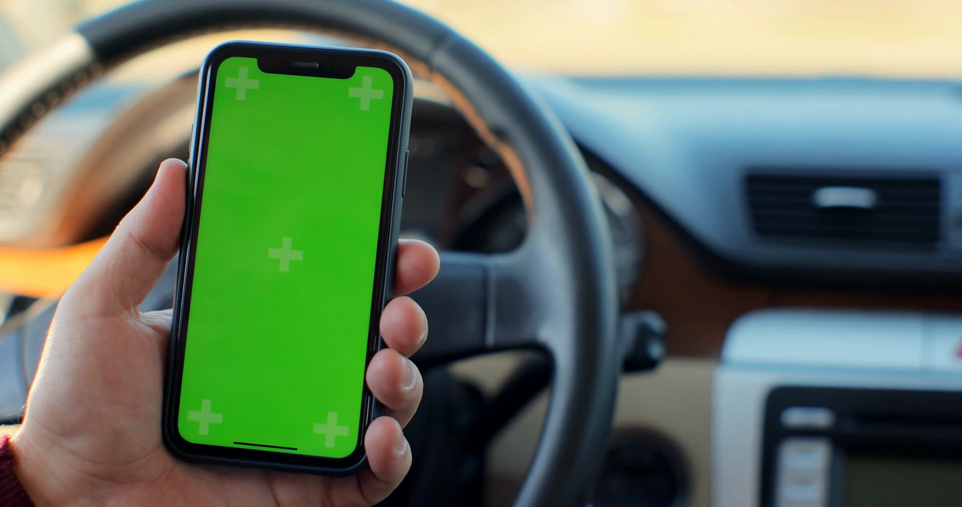 Man sitting at modern car using smartphone with green screen chroma key ...