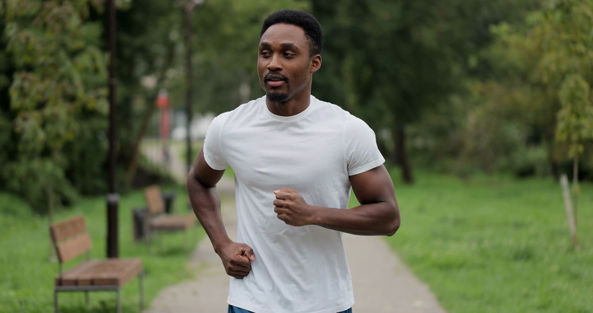 Portrait of tired black runner man breathing after run in city park ...
