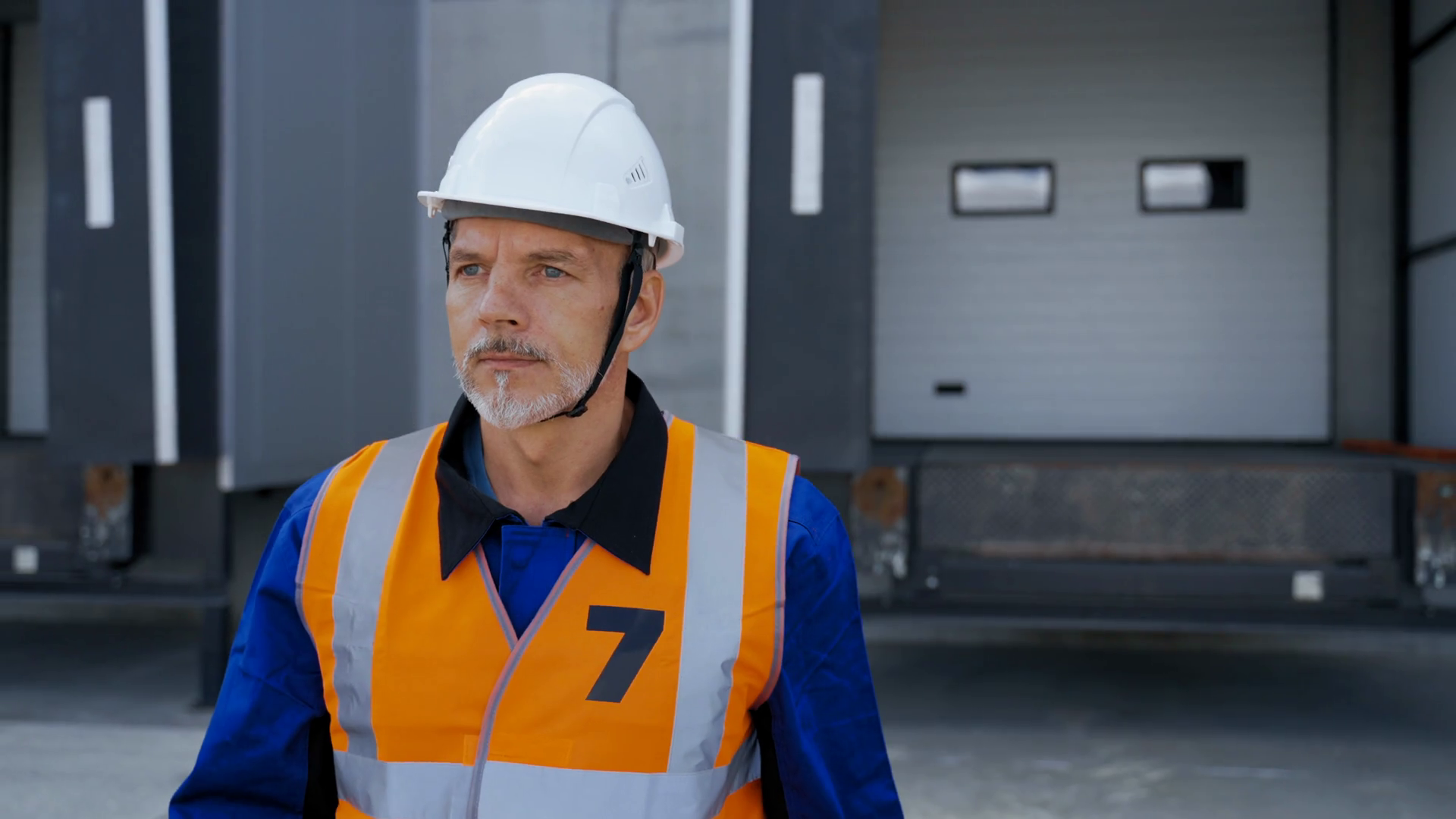 Serious engineer in white helmet walks against open gates Stock Video ...