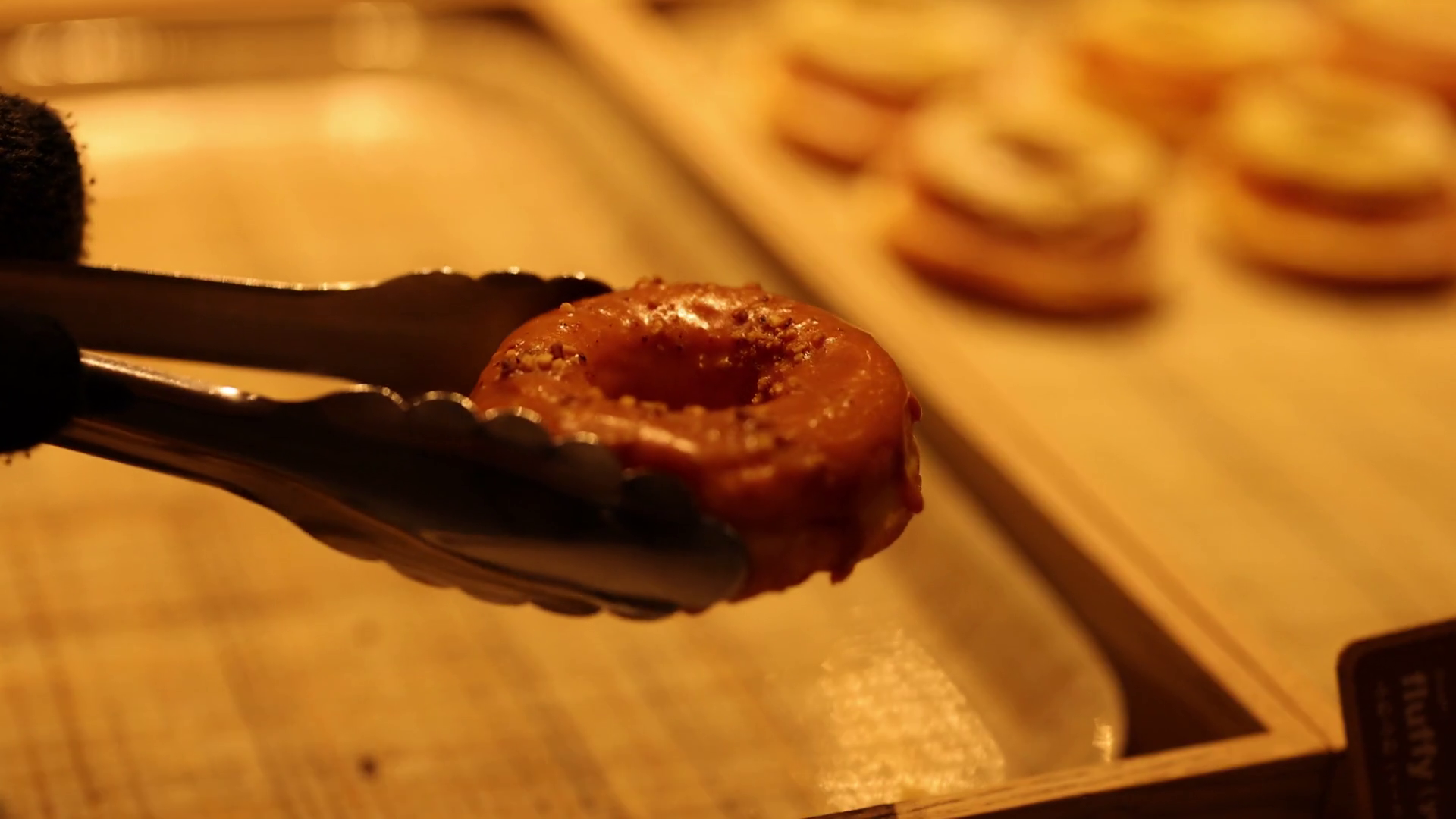 Tongs Picking Up Glazed Donut Stock Footage SBV-352756356 - Storyblocks