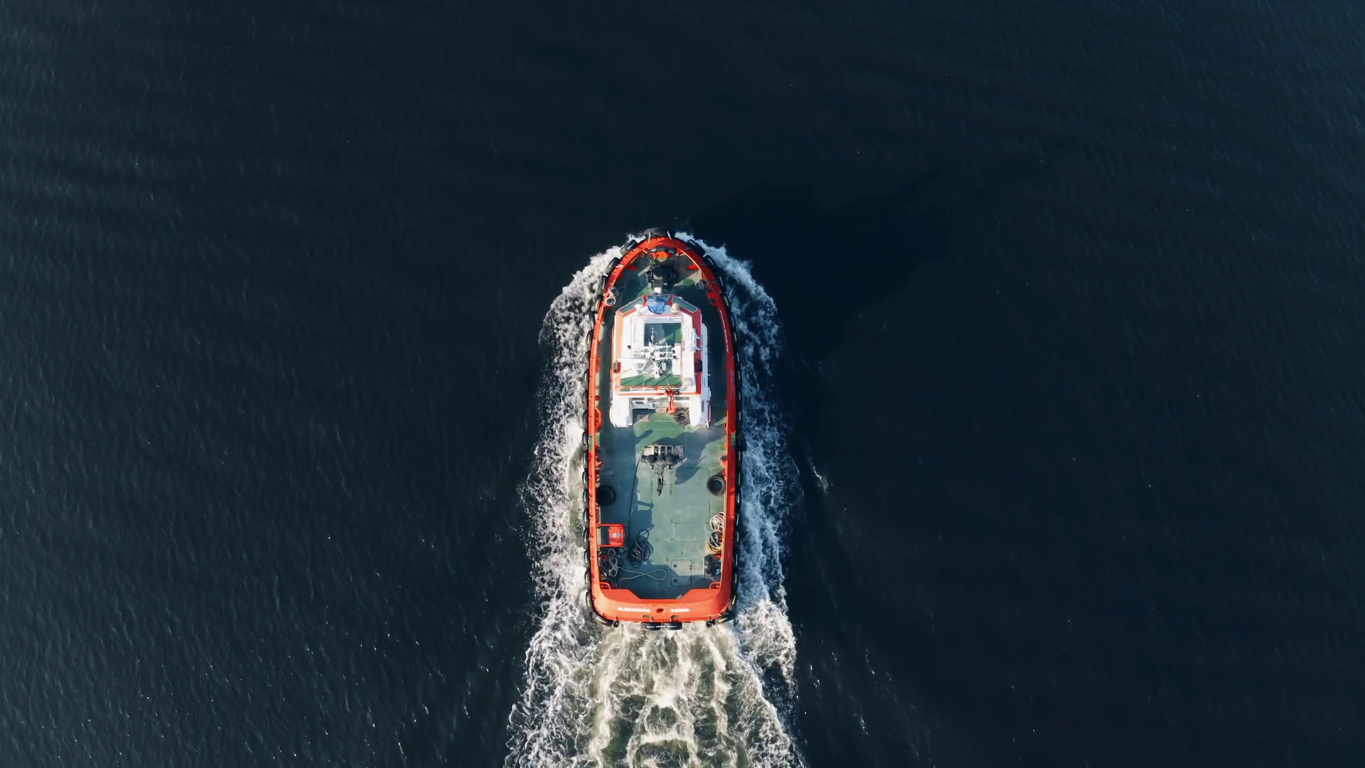 Floating pilot ship on calm surface of sea water on blue surface of sea at sunset aerial view ...