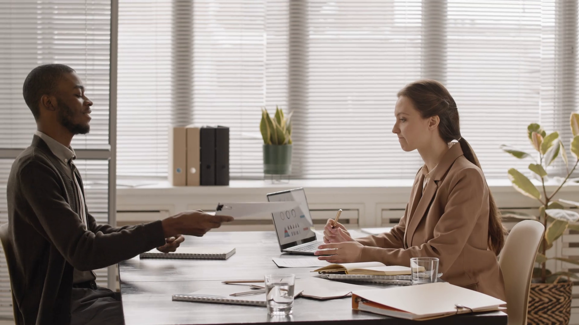 Side view medium slowmo of young Black man giving his resume to female ...