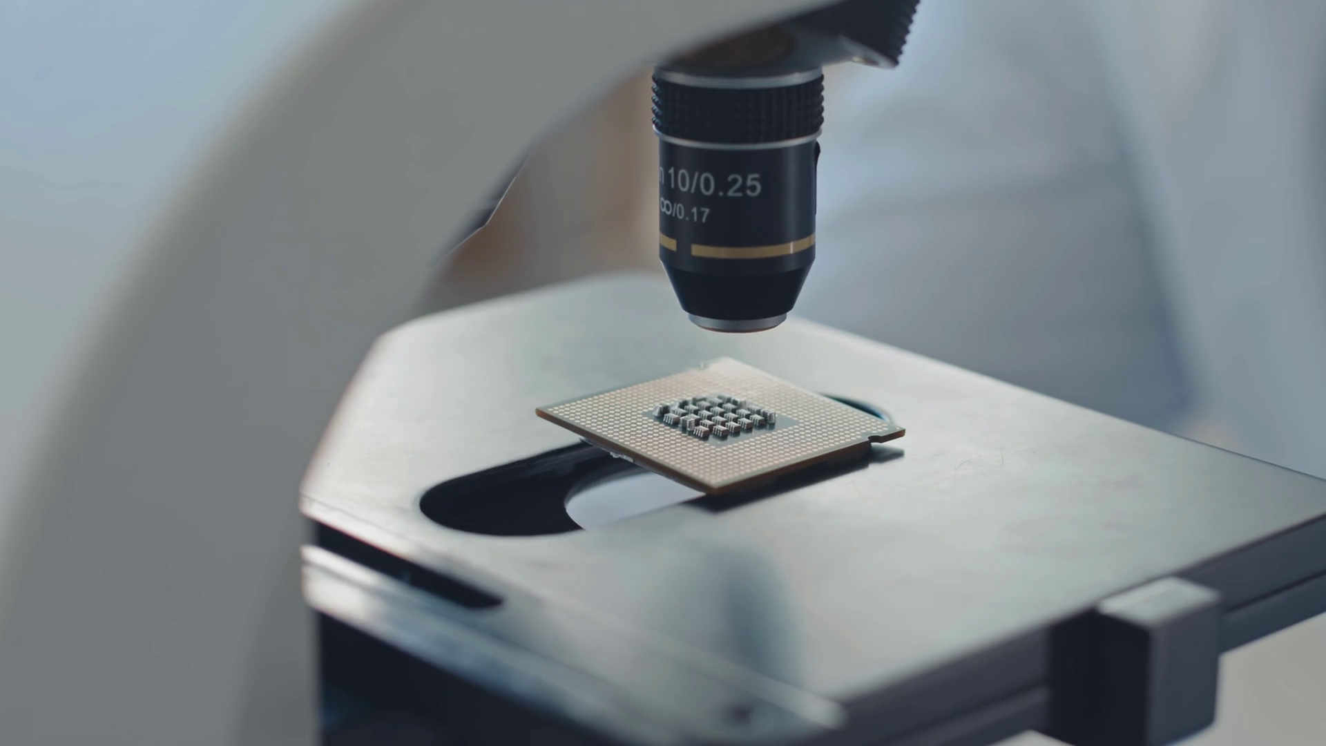 Slowmo closeup of computer chip under microscope being inspected by ...