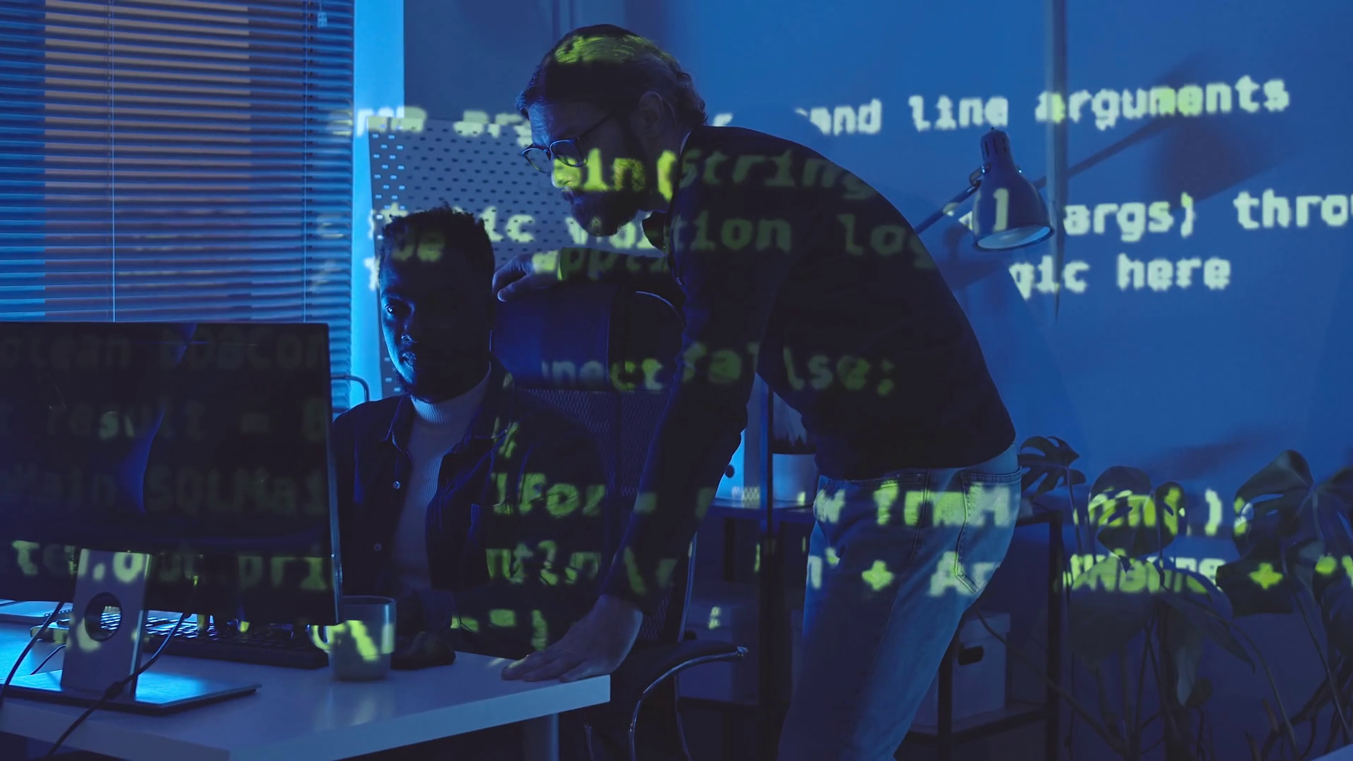 Medium shot of running programming code projecting on office interior ...