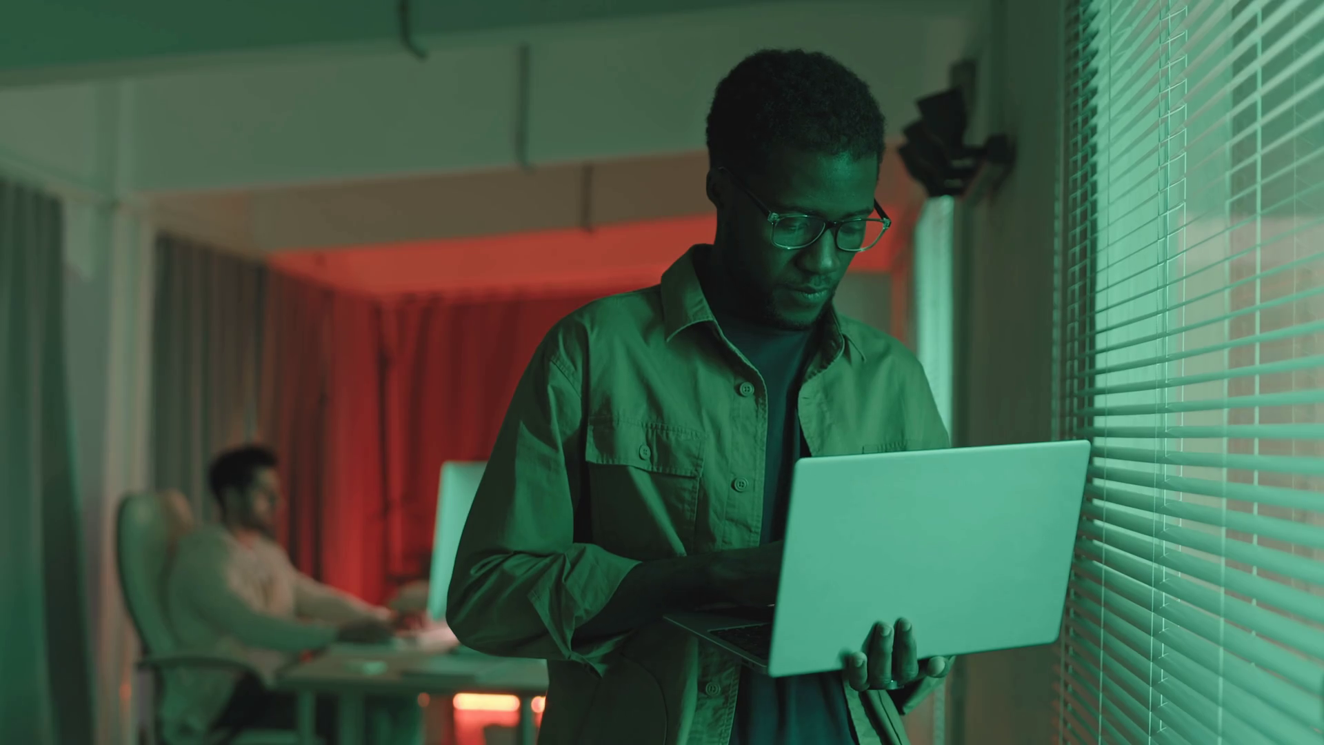 Waist-up slowmo shot of young African-American programmer typing on ...