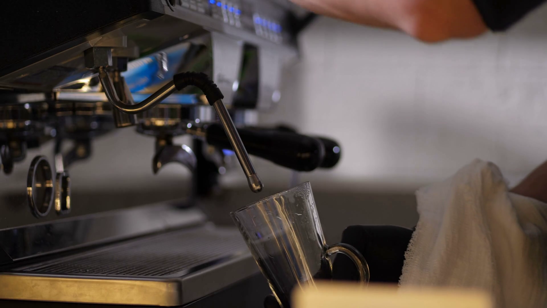 Close-up professional coffee machine steaming glass through branch pipe ...