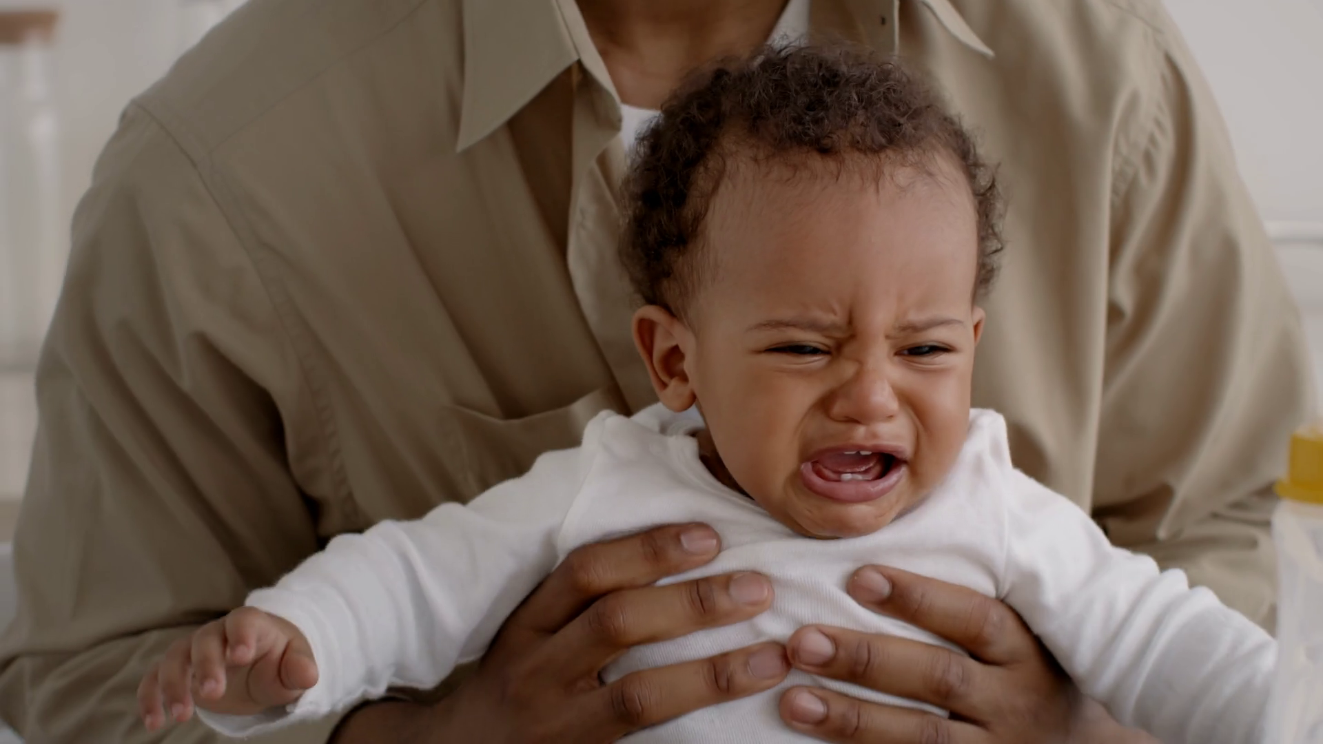 Close up portrait of sad african american baby boy crying in fathers ...