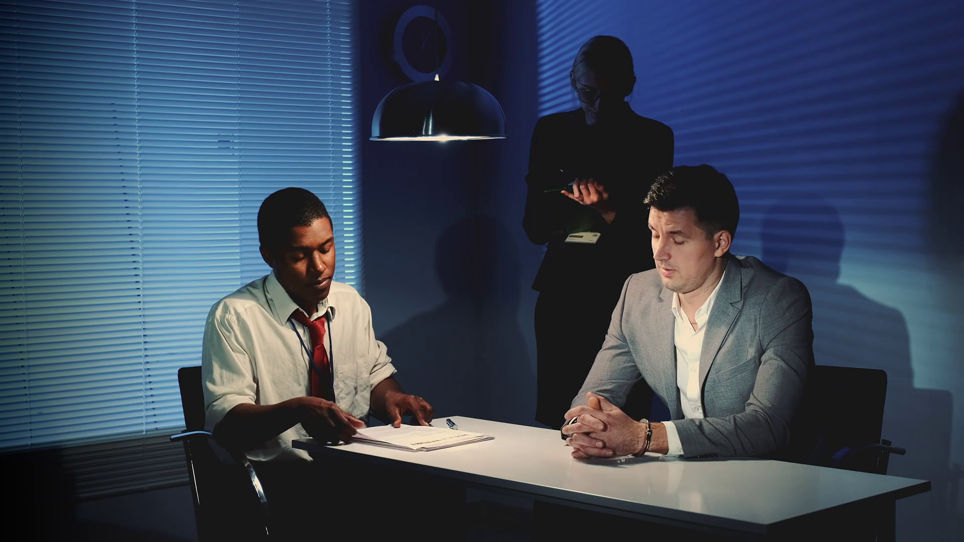 Accused young man crumpling a document with accusation in interrogation ...