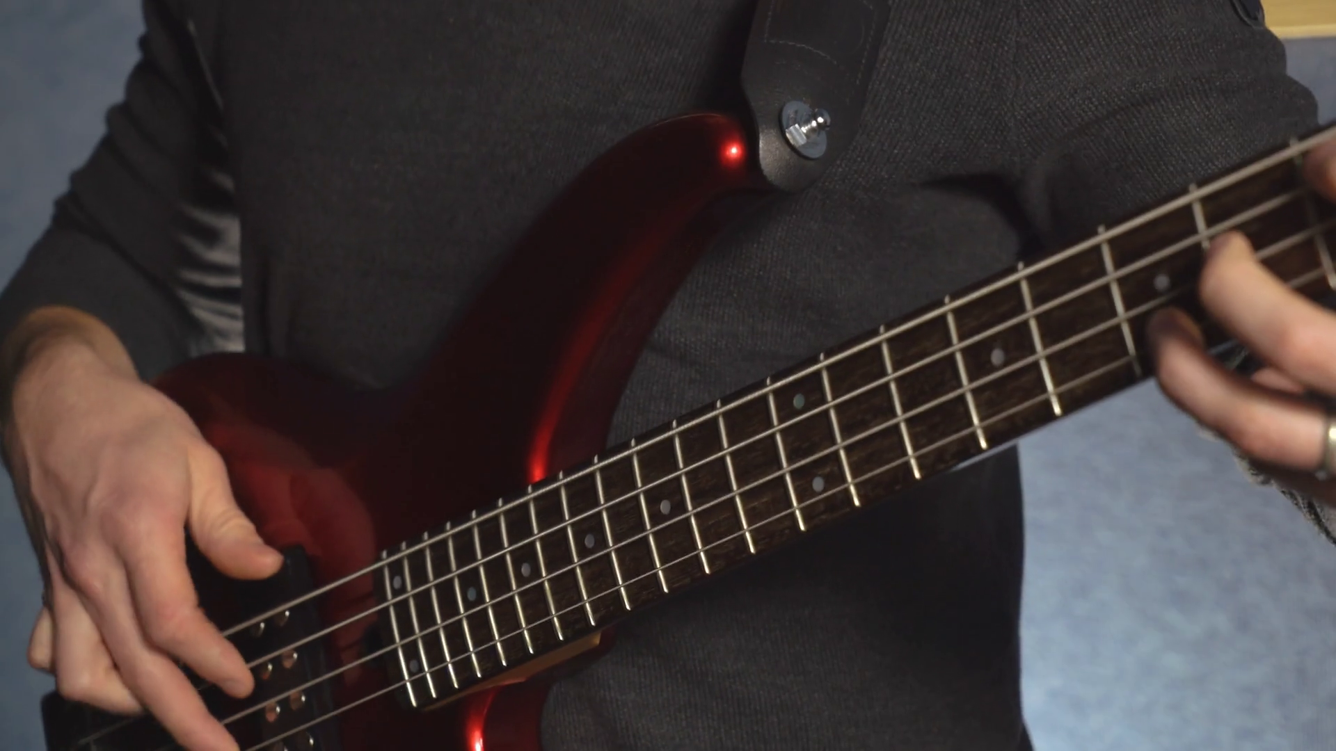 Man playing on the guitar close up. Guy hands pluck the strings on red ...