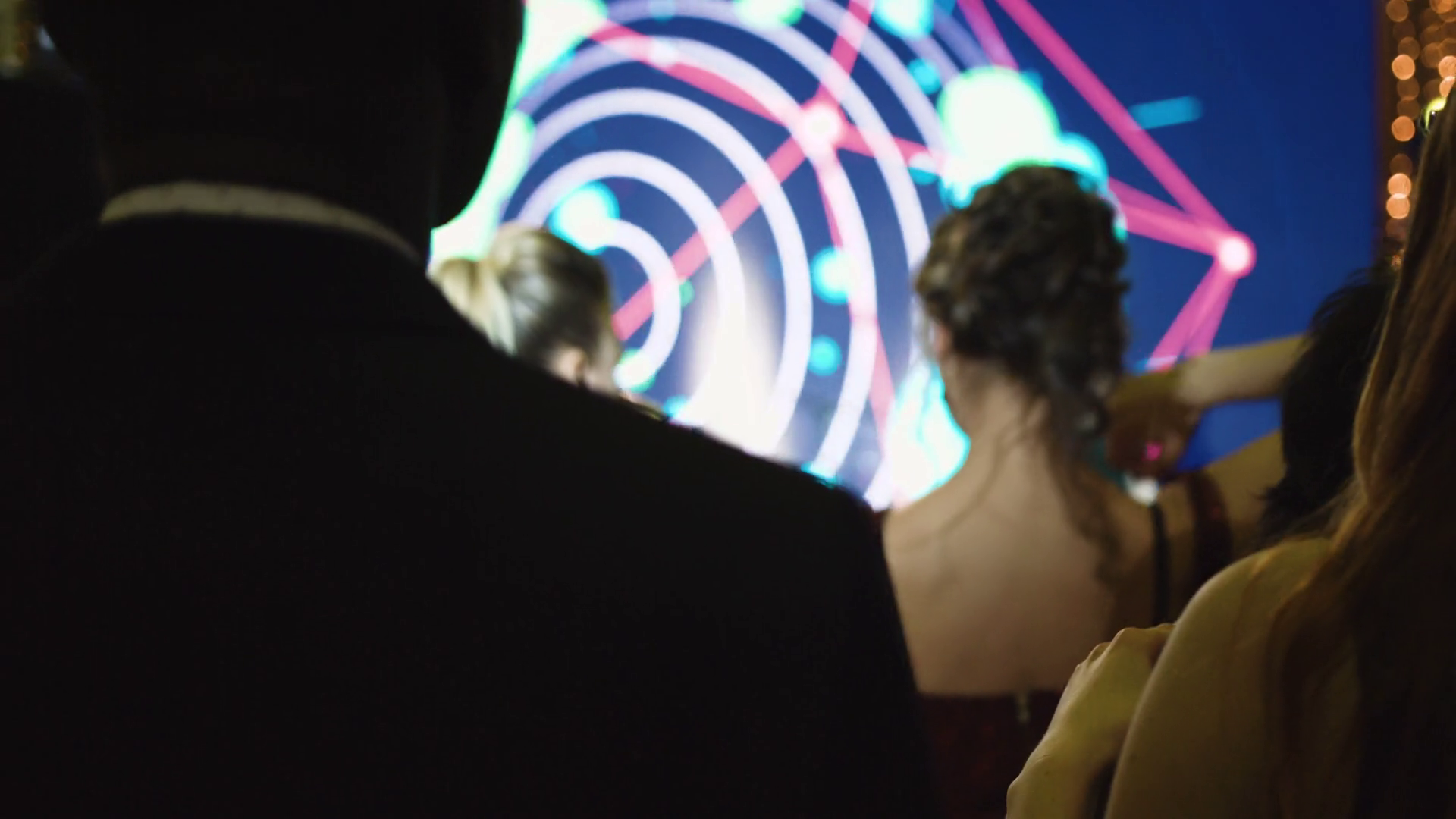 A group of attractive silhouetted young adults dance in a smokey club ...