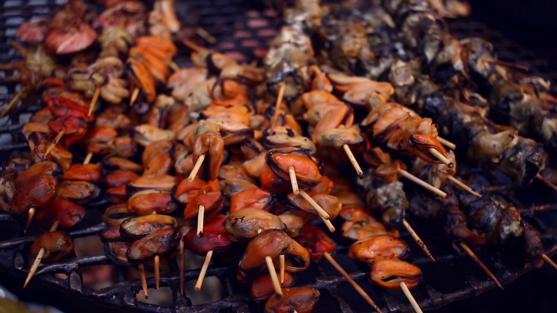 Grilled mussels on skewers. Barbecue food on skewers on grill. Seafood ...