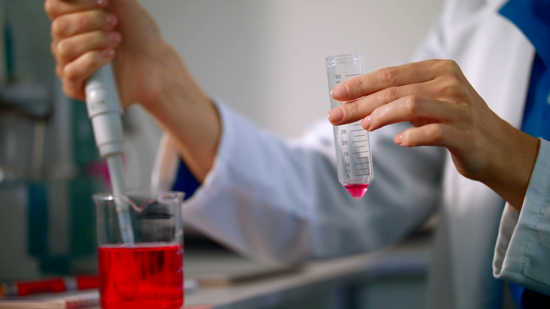 Scientist hand pouring liquid in glass flask close up. Woman scientist ...
