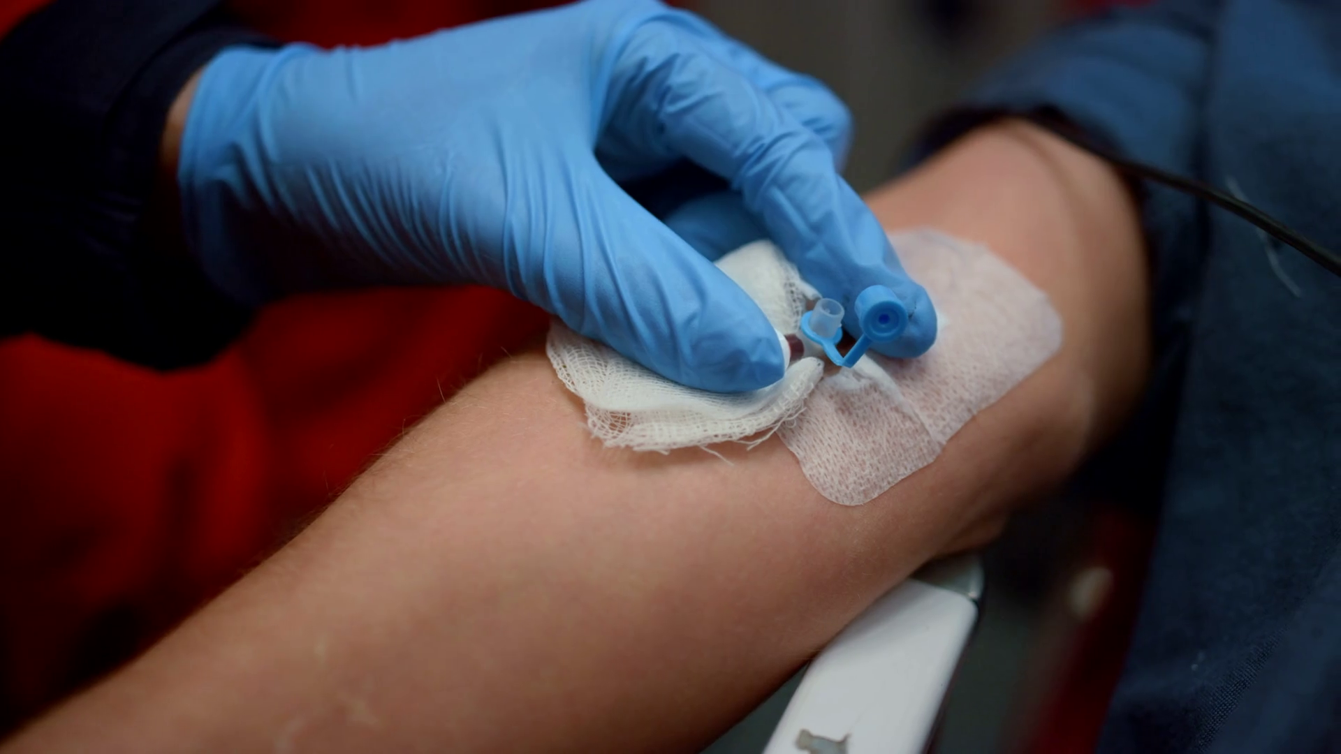 Medical worker in gloves inserting iv fluids into patient arm with ...