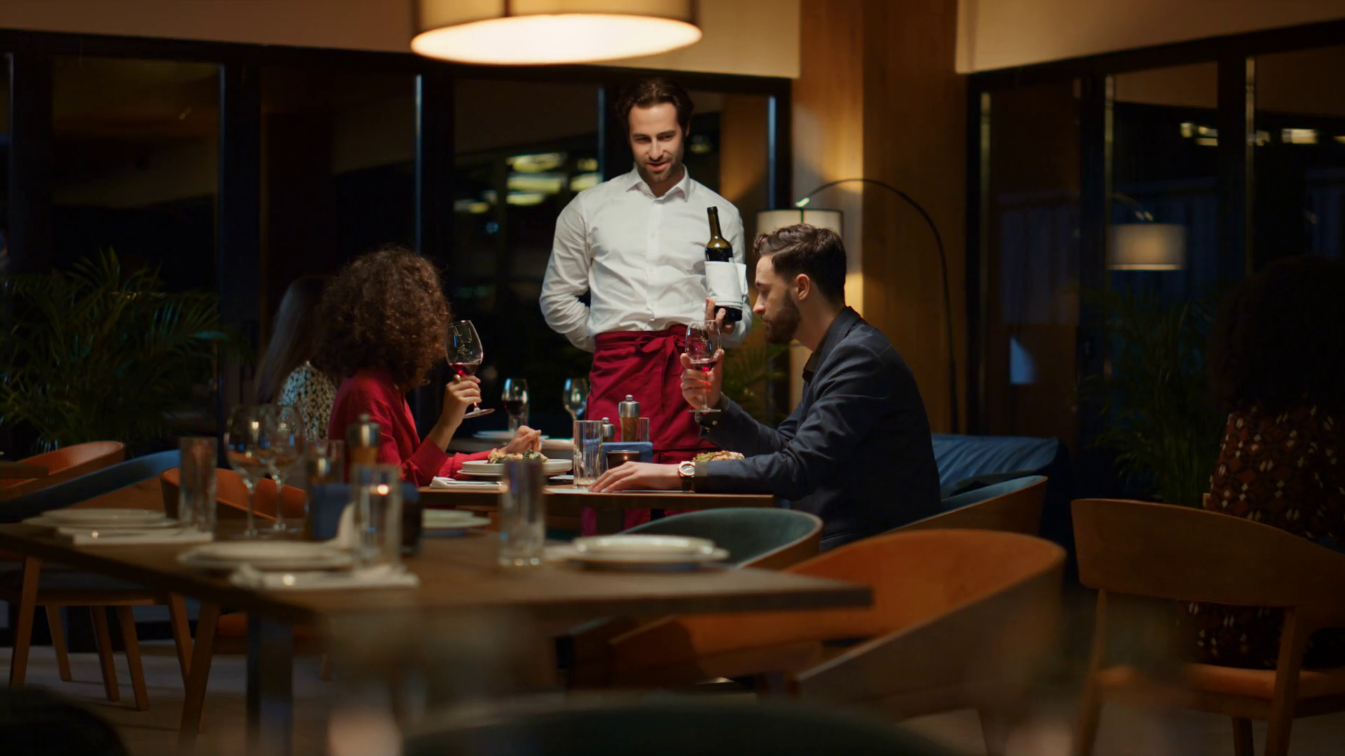 Waiter serving romantic couple in loft interior restaurant table ...