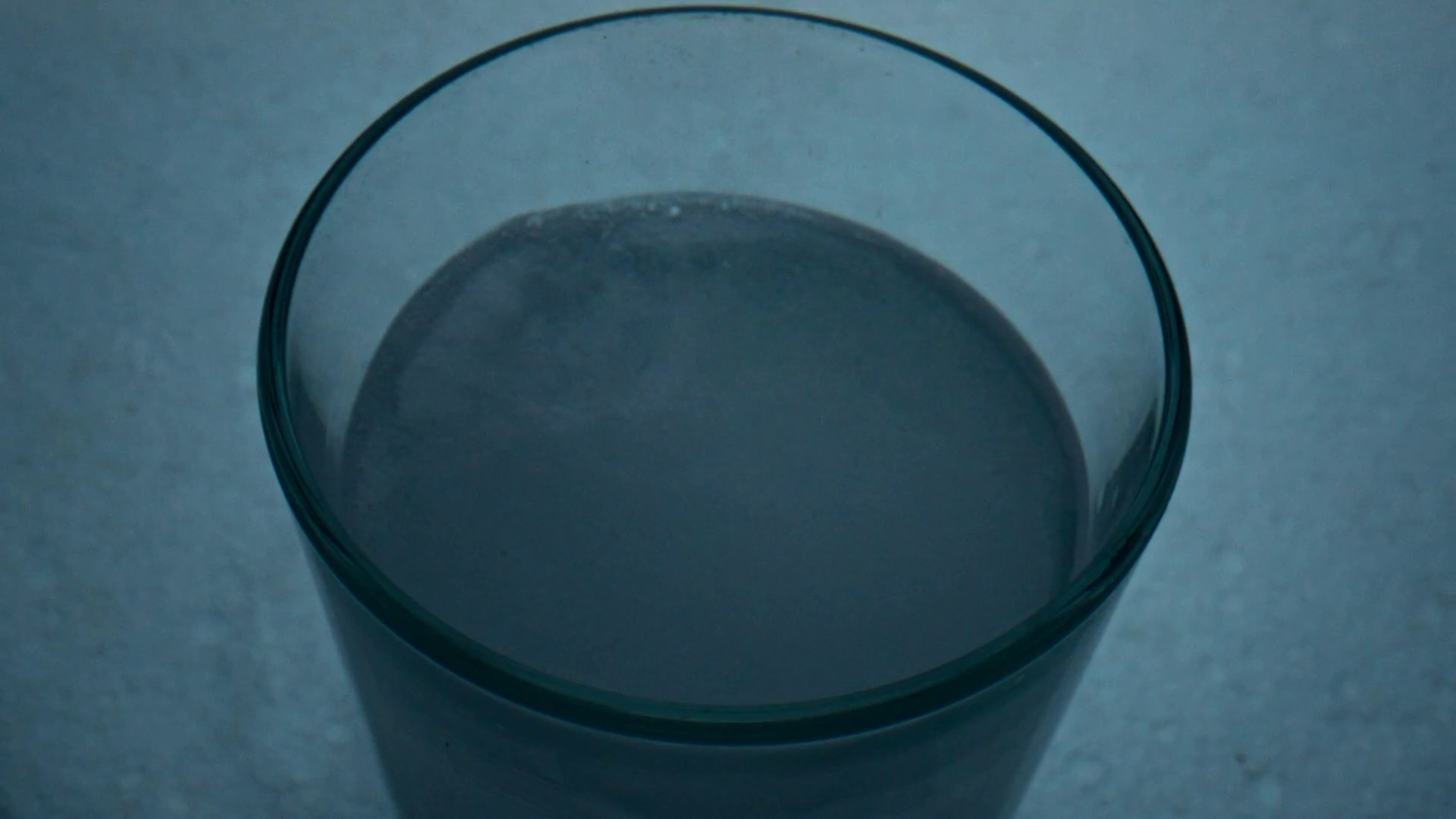 Top view effervescent bubbling in glass closeup. Air bubbles rising exploding on water surface ...
